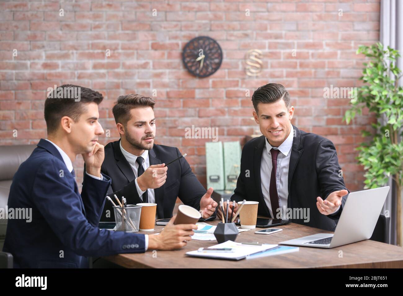 Men in elegant suits at workplace Stock Photo - Alamy