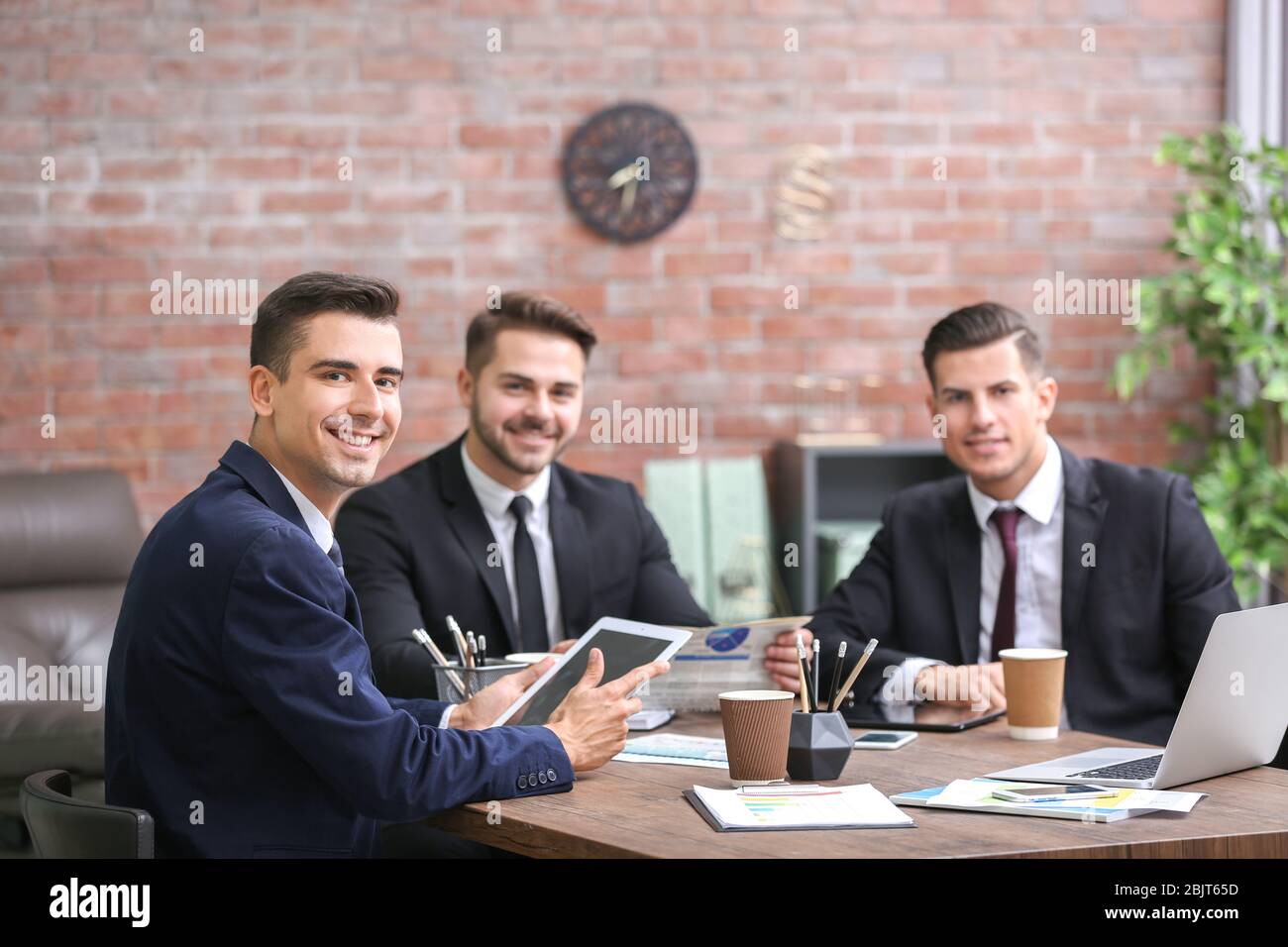 Men in elegant suits at workplace Stock Photo - Alamy