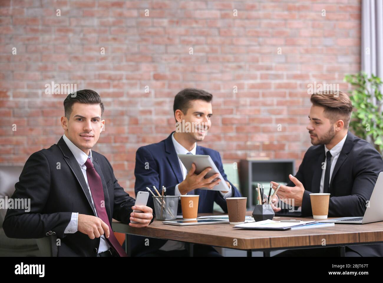 Men in elegant suits at workplace Stock Photo - Alamy