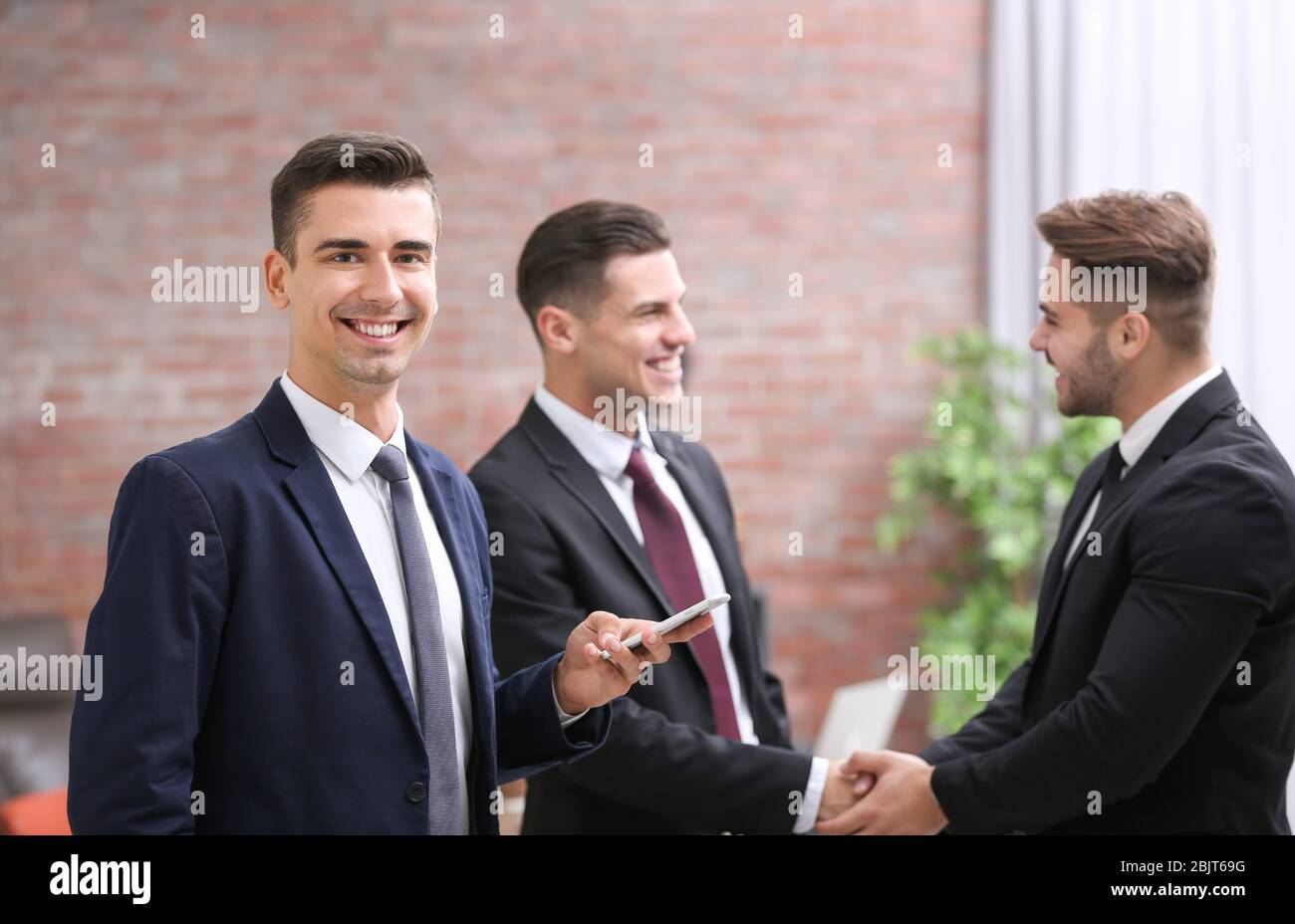 Men in elegant suits at workplace Stock Photo - Alamy