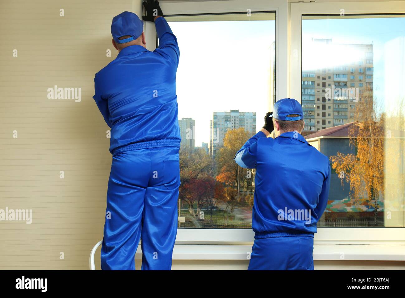 Construction workers repairing window in house Stock Photo - Alamy