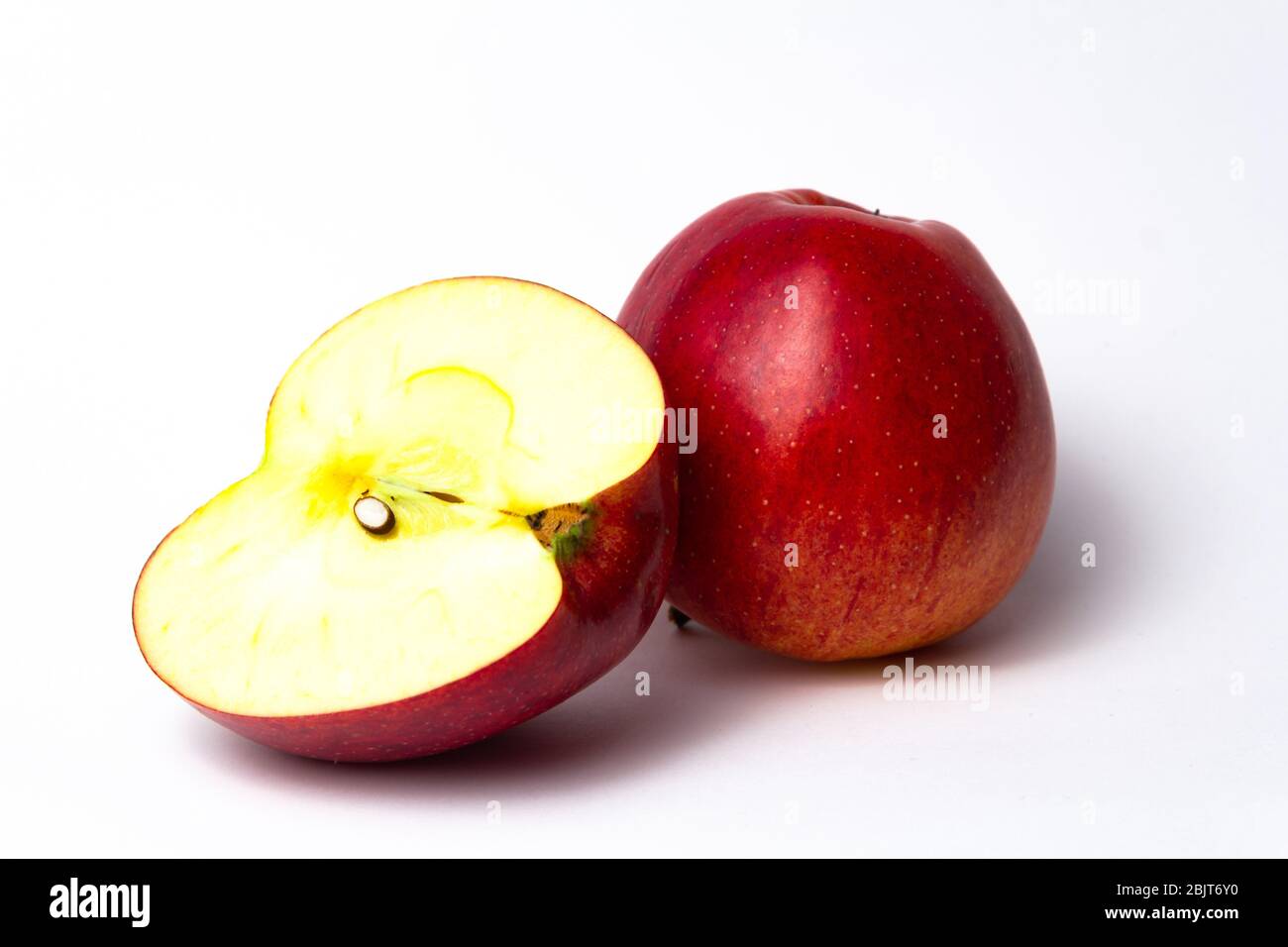 red apple cut in half on a white background Stock Photo - Alamy