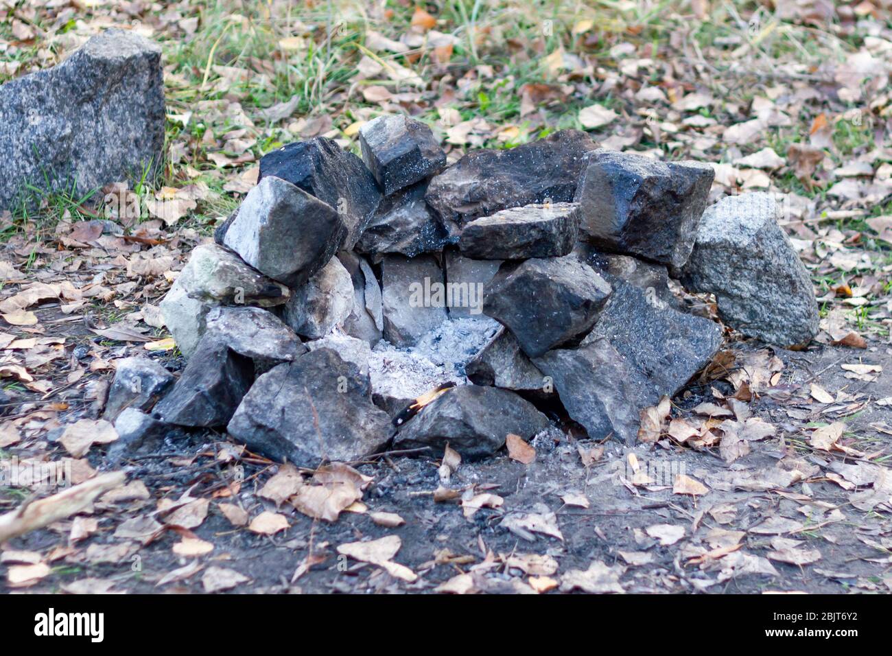 Stone fire bonfire burning sticks firewood in autumn Stock Photo - Alamy
