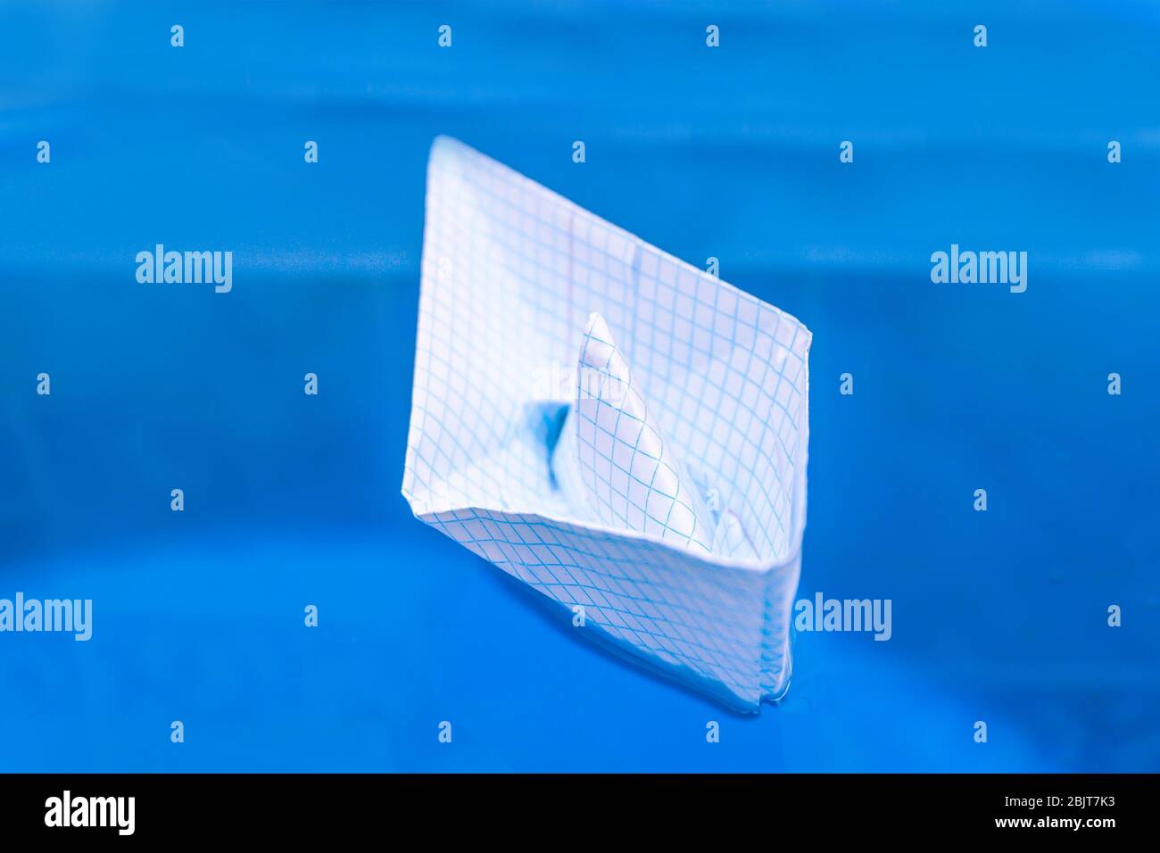 checkered paper boat in blue water Stock Photo - Alamy