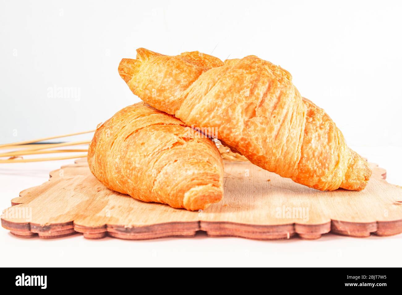 croissants with dry wheat on a wooden board on a white background Stock ...