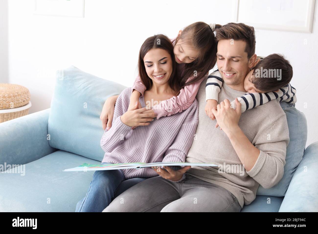 Happy family reading book at home Stock Photo - Alamy