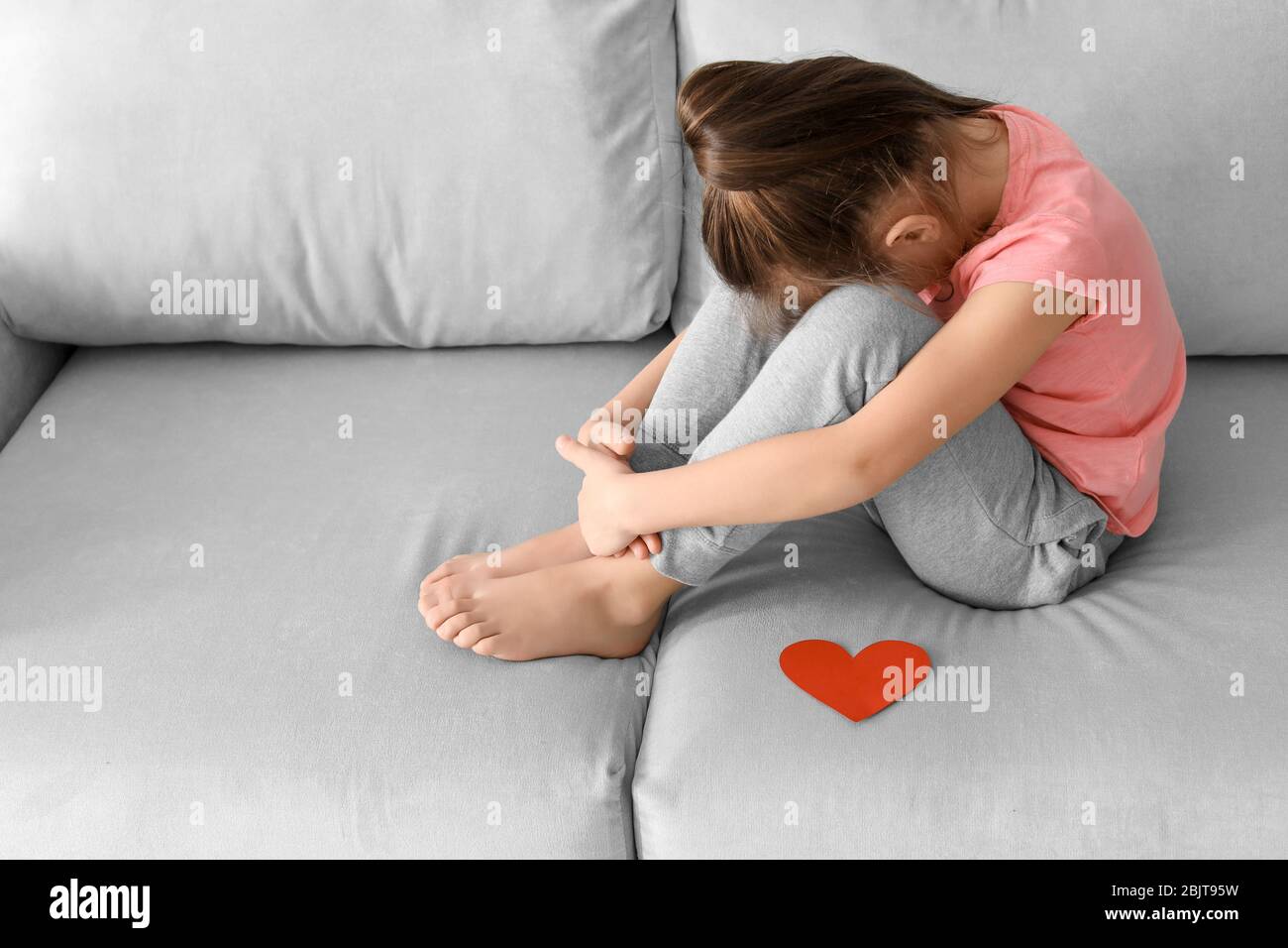 Little girl crying near paper heart at home. Child autism Stock Photo ...