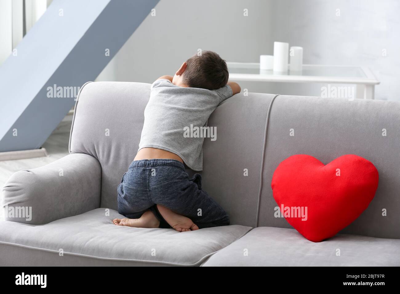 Little boy sitting on sofa at home. Child autism Stock Photo - Alamy