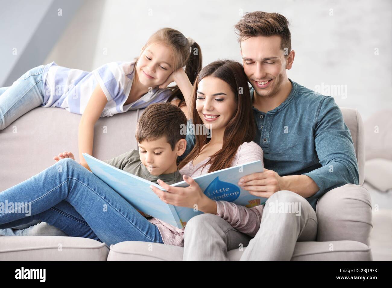 Happy family reading book at home Stock Photo - Alamy