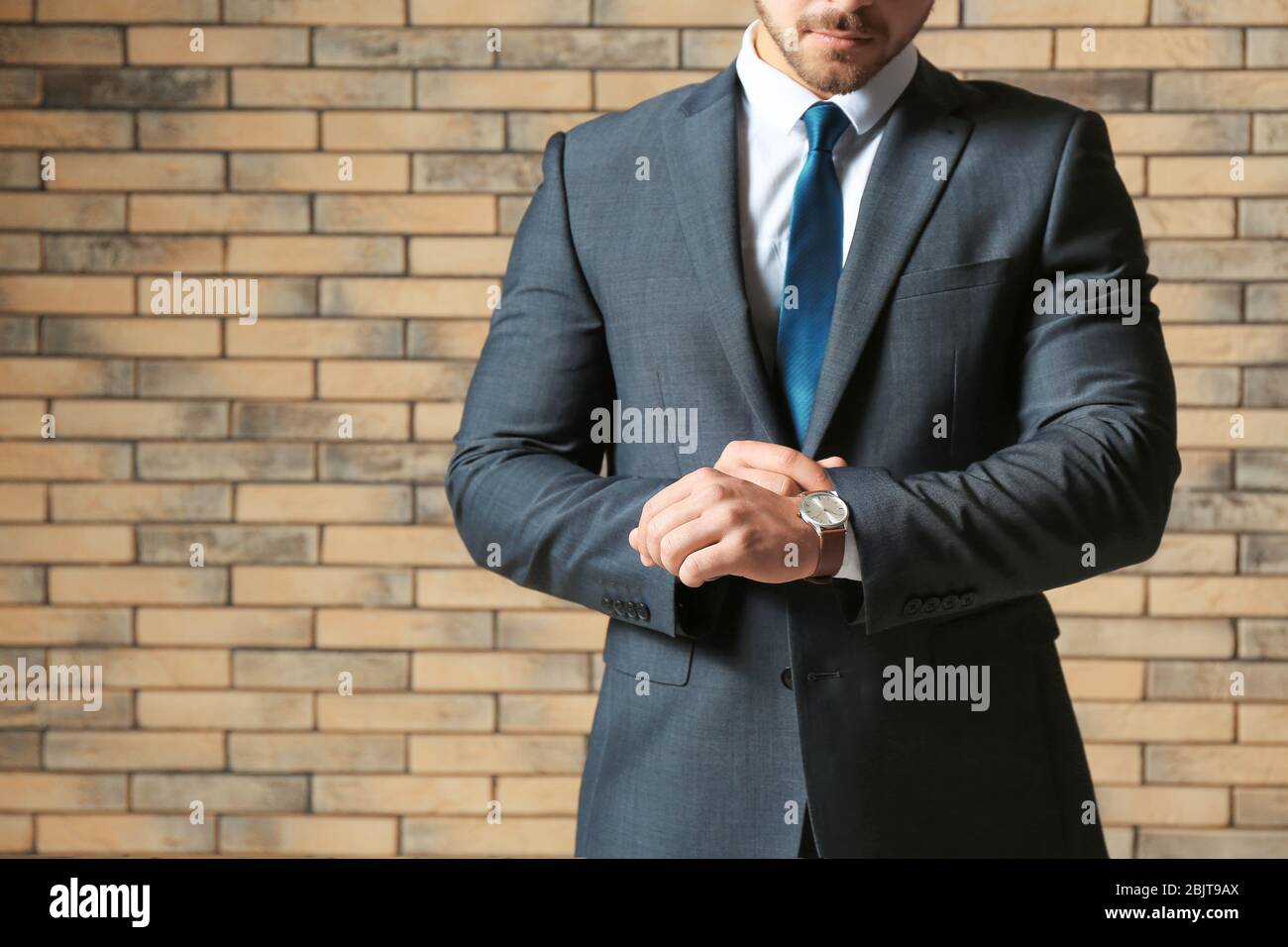 Handsome man in formal suit against brick wall, closeup Stock Photo - Alamy