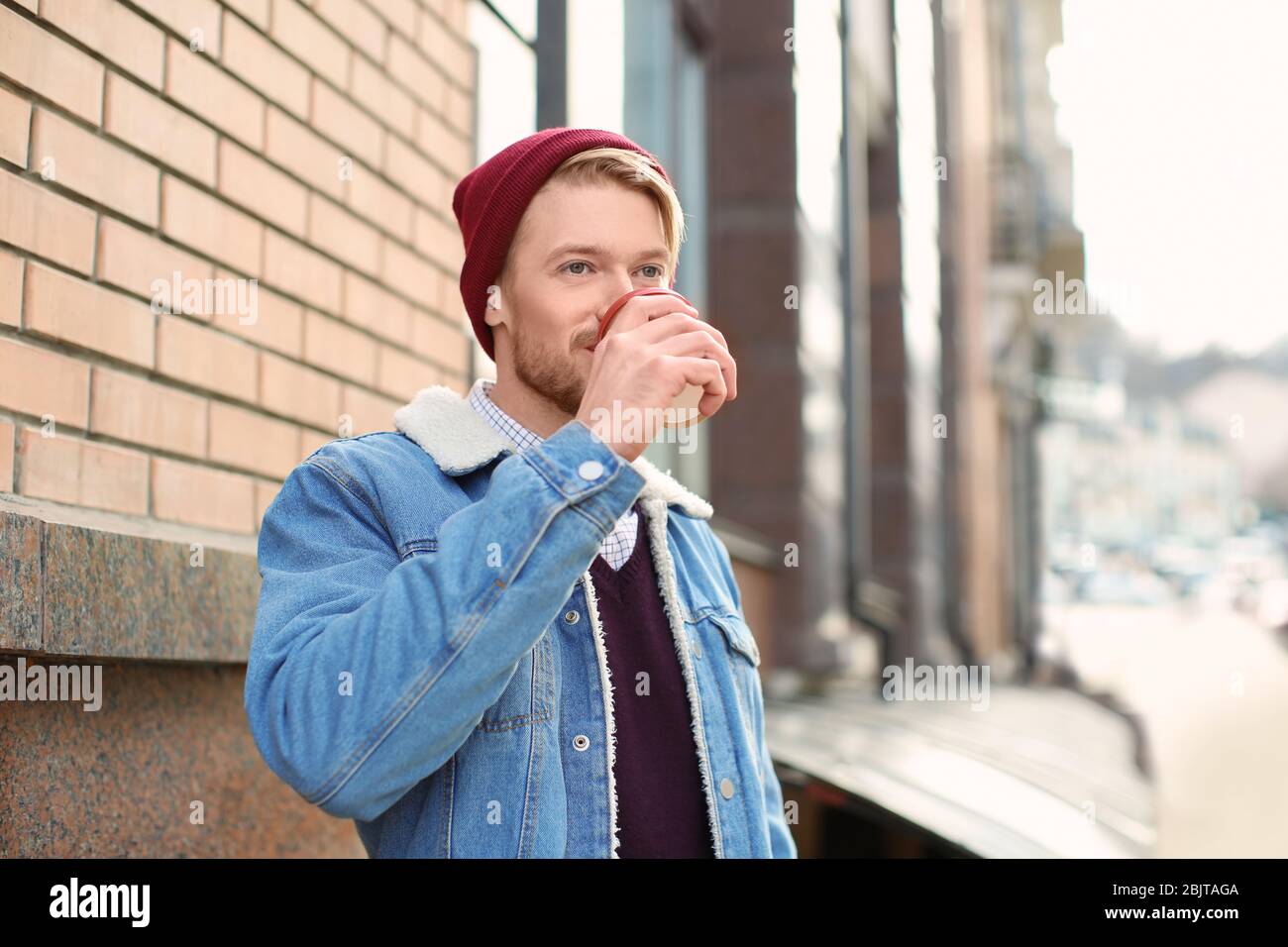 Portrait of trendy hipster drinking coffee outdoors Stock Photo - Alamy
