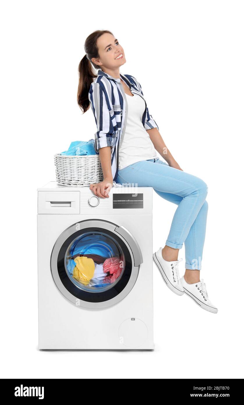 Woman with laundry basket sitting on washing machine against white ...