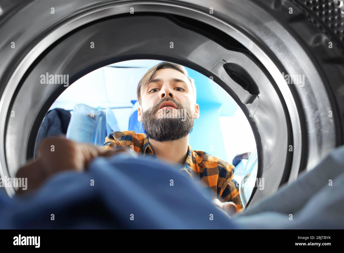 Man washing clothes launderette hi-res stock photography and images - Alamy