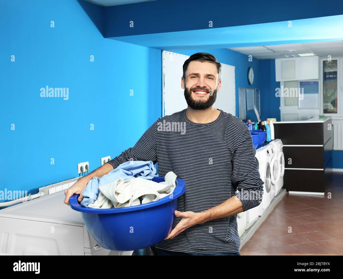 Man washing clothes launderette hi-res stock photography and images - Alamy