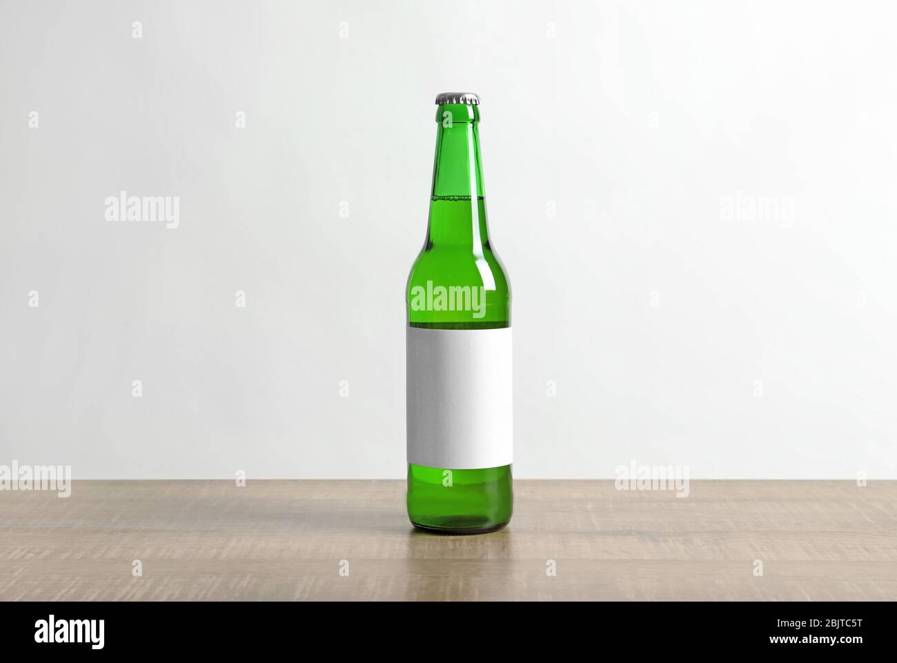 Bottle of drink on table against white background. Mockup for design ...