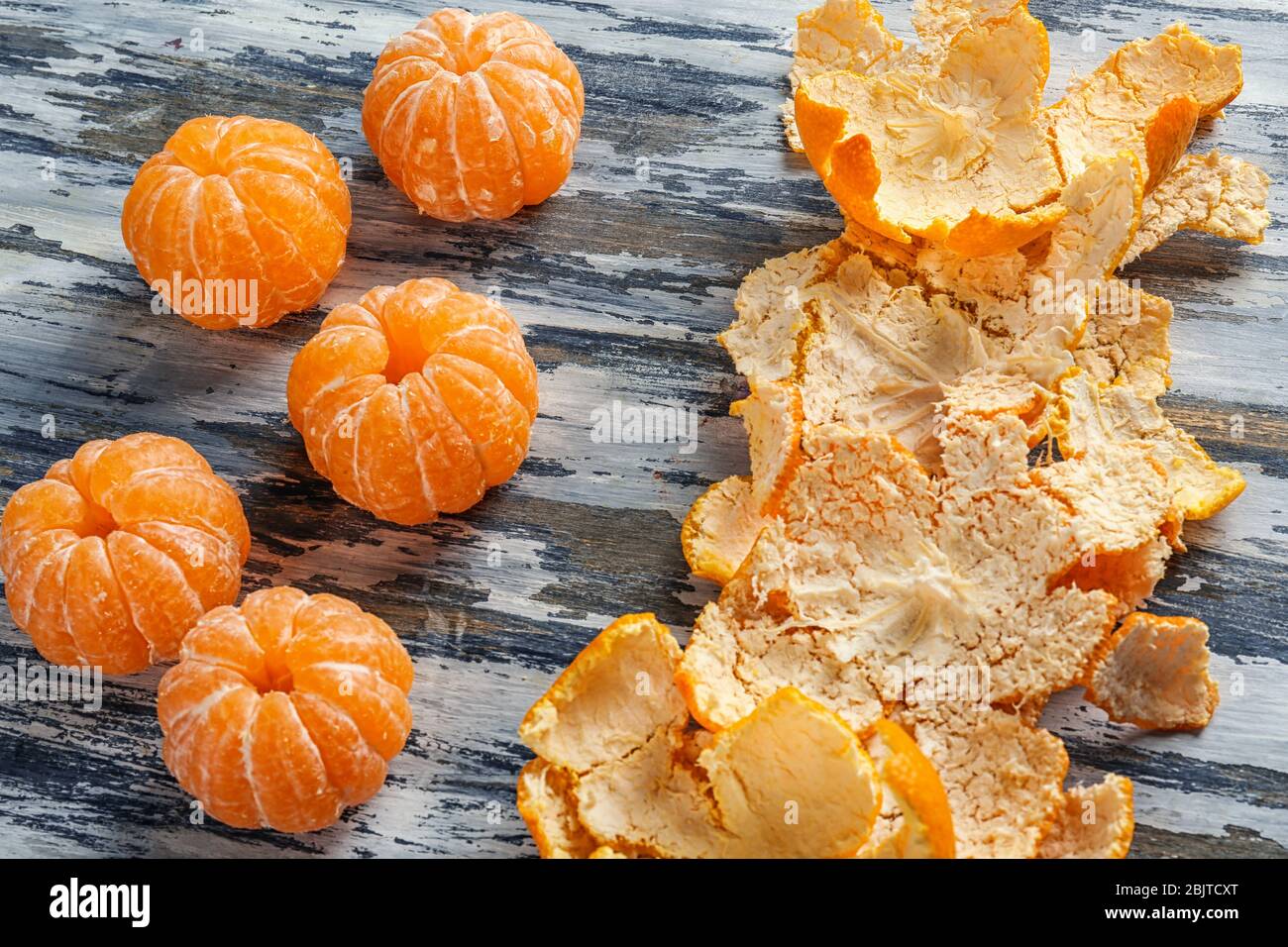 Juicy peeled tangerines and skin on wooden table Stock Photo - Alamy