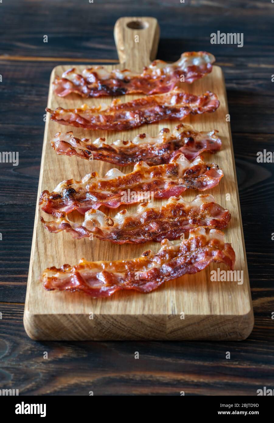 Fried bacon strips on the wooden board Stock Photo - Alamy