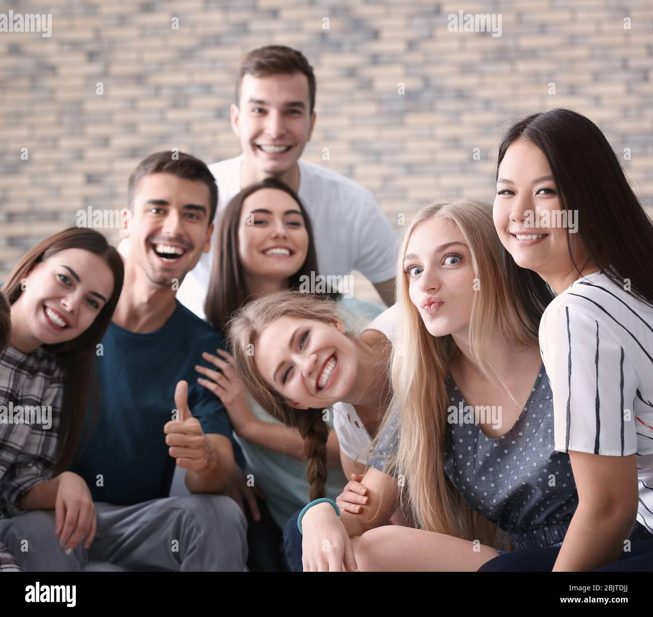 People sitting together near brick wall. Unity concept Stock Photo - Alamy