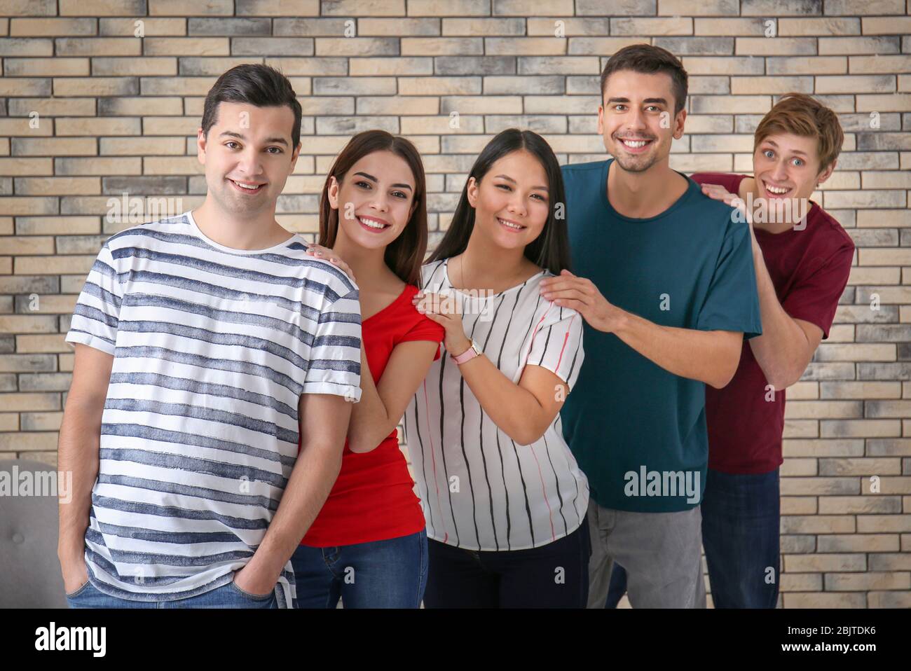 People standing together near brick wall. Unity concept Stock Photo - Alamy