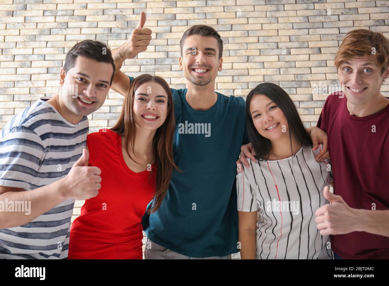 People standing together near brick wall. Unity concept Stock Photo - Alamy
