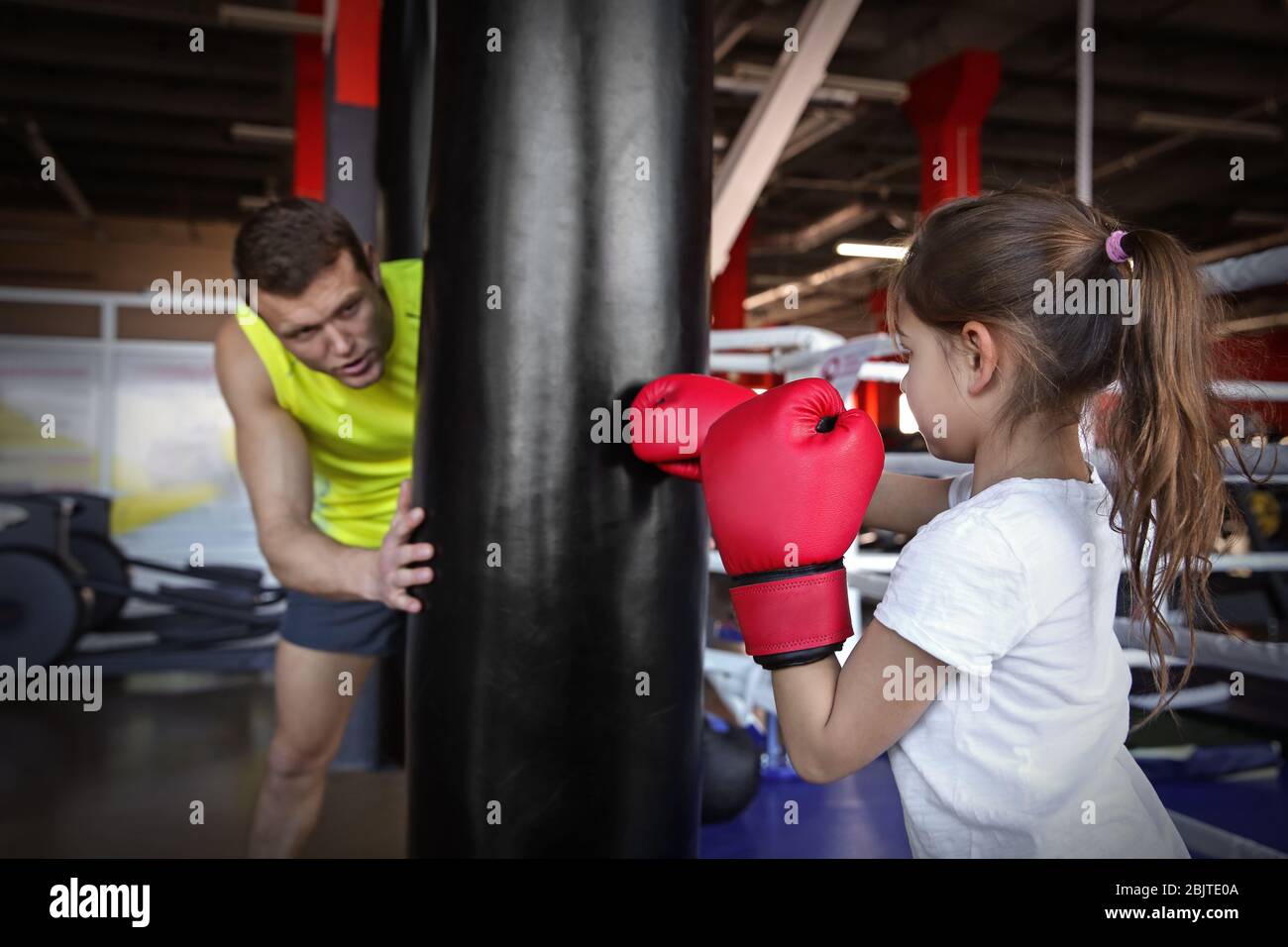 Little girl training with coach and punchbag in boxing gym Stock Photo ...