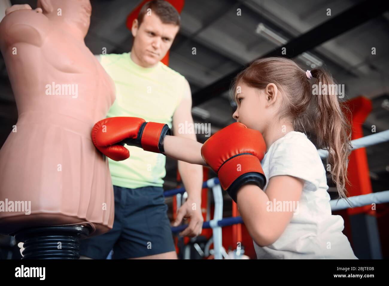Little girl training with coach and dummy in boxing ring Stock Photo ...