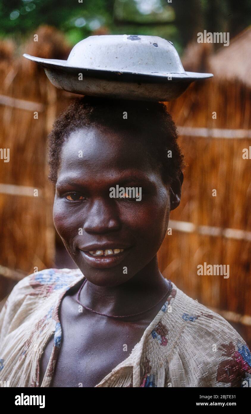 Sudanese Woman carrying a plate of food on her head in a village near ...