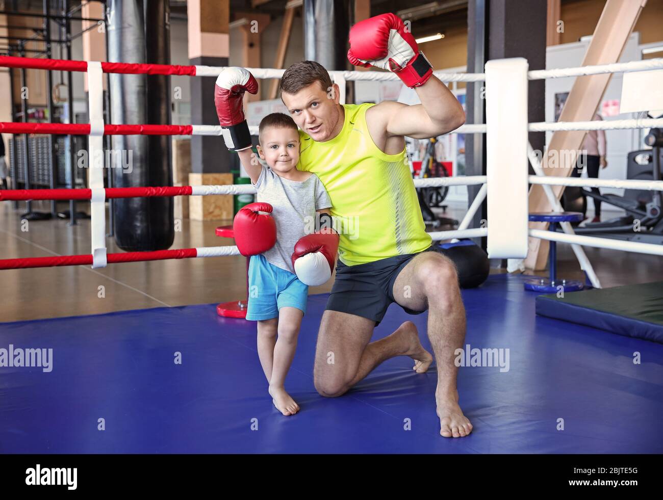 Little boy with trainer in boxing ring Stock Photo - Alamy