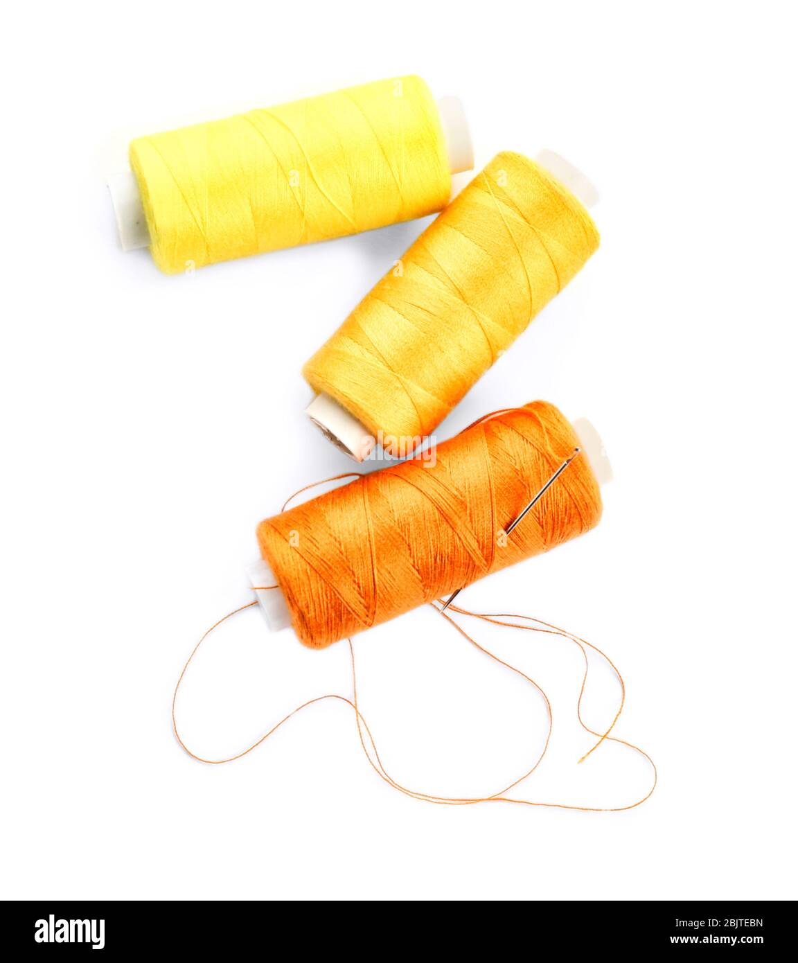 Spools of sewing threads and needle on white background Stock Photo - Alamy