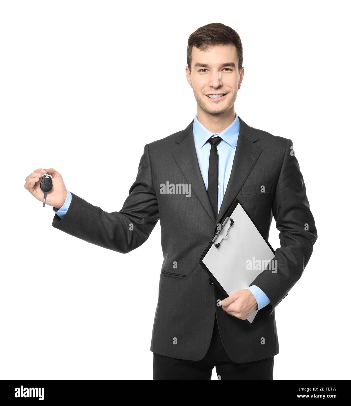 Handsome car salesman with key and clipboard on white background Stock ...