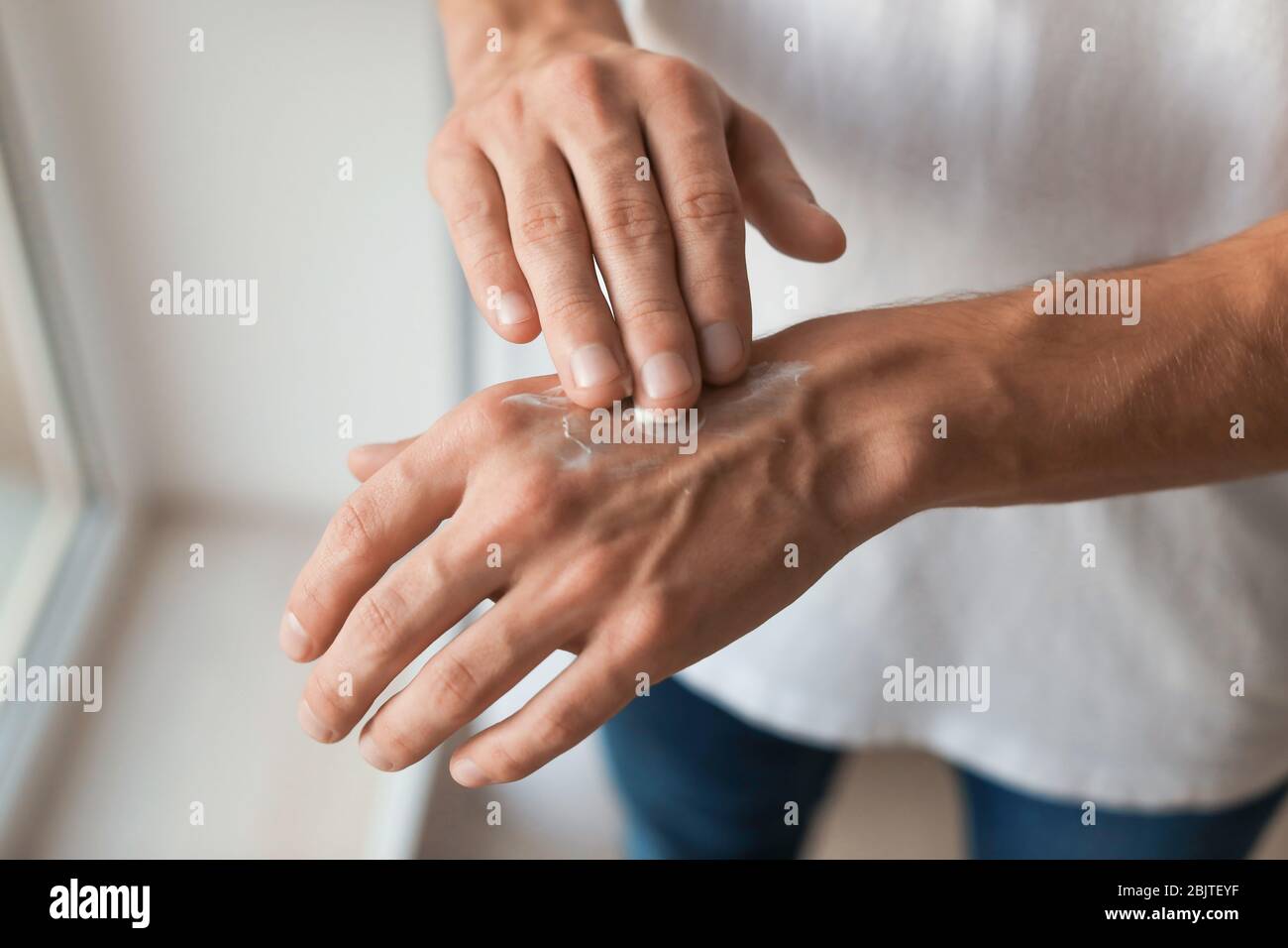 Man applying hand cream, closeup Stock Photo - Alamy