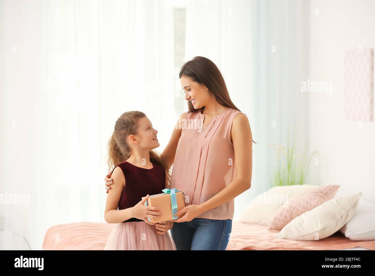 Cute little girl giving gift box to her mom indoors. Mother's day celebration Stock Photo - Alamy
