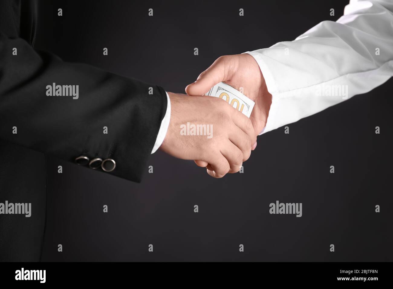 Doctor taking bribe from businessman on black background Stock Photo ...