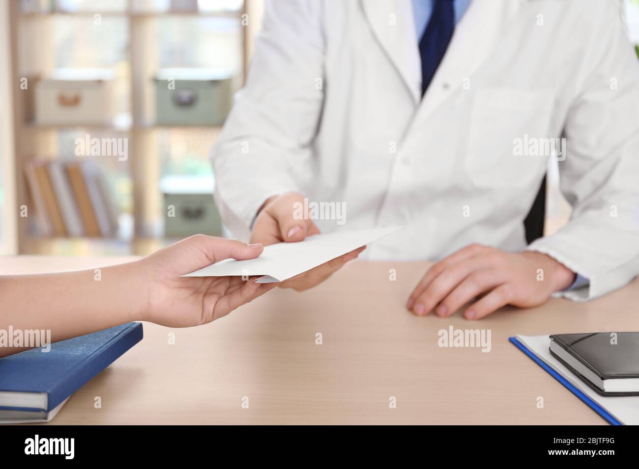Doctor taking bribe from woman at workplace Stock Photo - Alamy