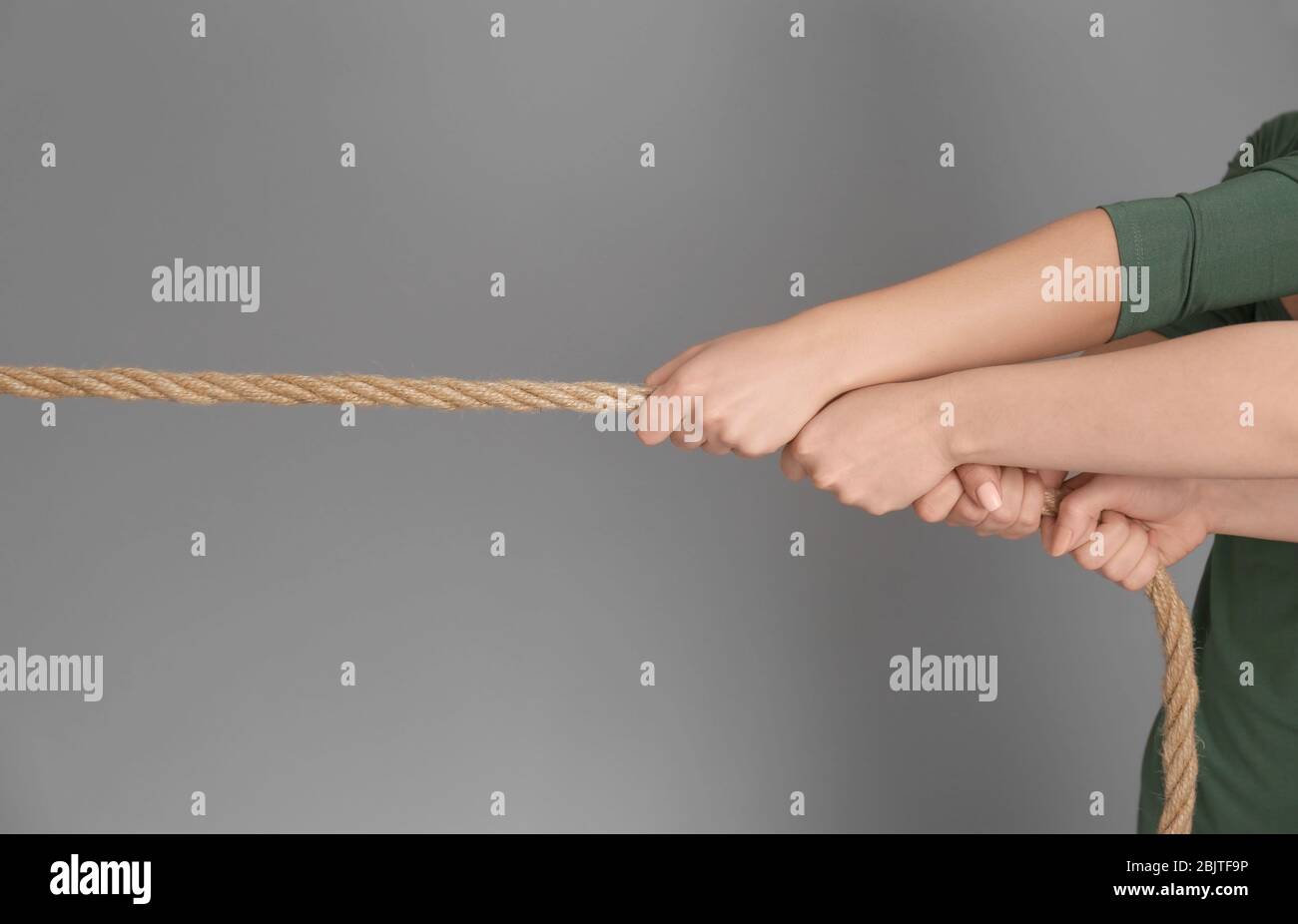 People pulling rope together on grey background. Unity concept Stock ...