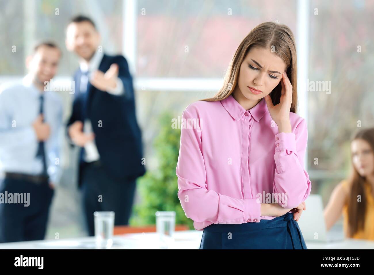 Coworkers bullying their colleague at work Stock Photo - Alamy