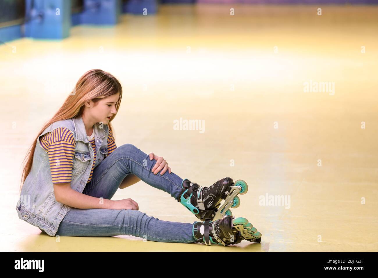 Teenage girl falling down at roller skating rink Stock Photo - Alamy