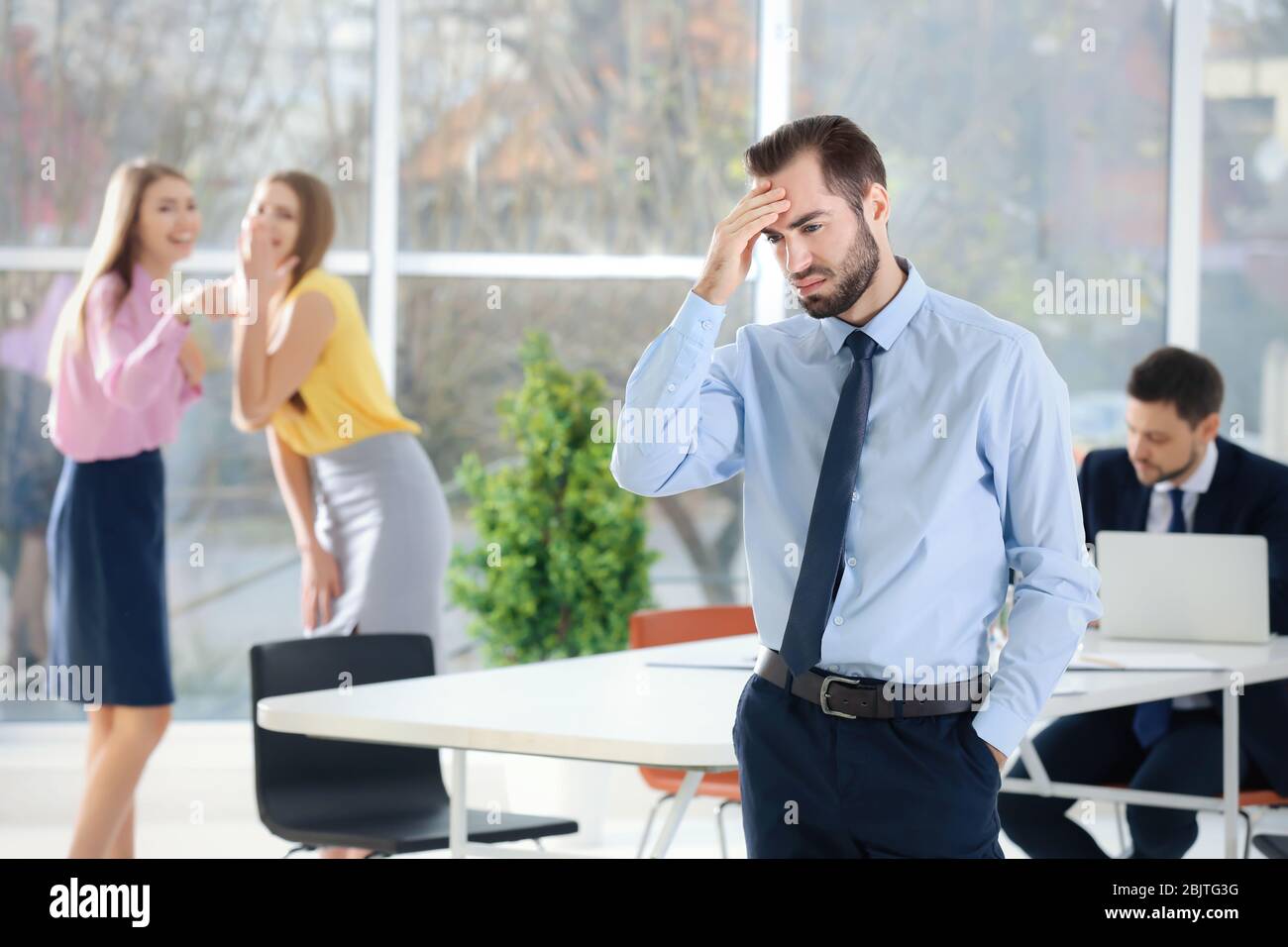 Coworkers bullying their colleague at work Stock Photo - Alamy