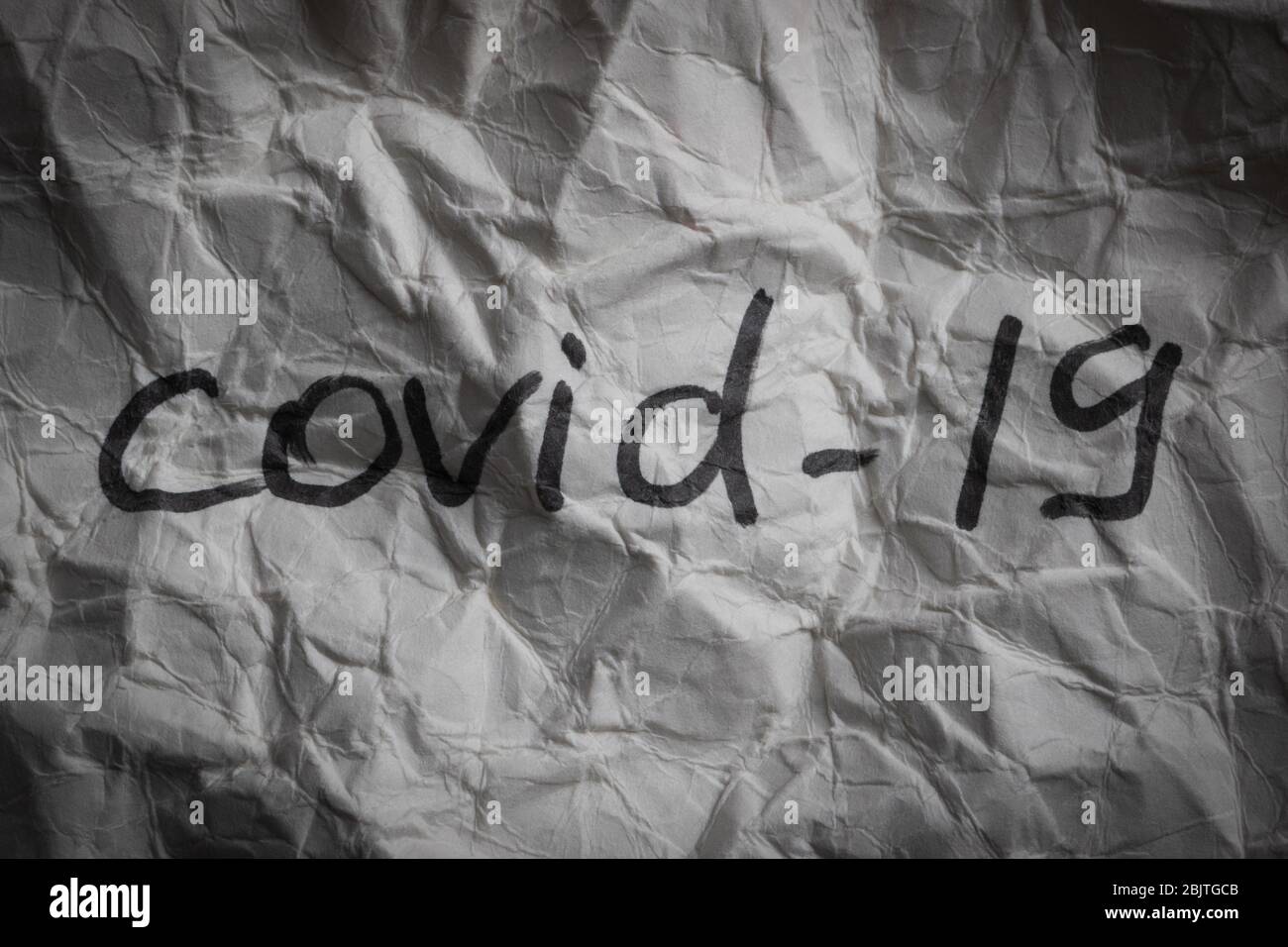 Dramatic covid-19 text on crumpled paper. Coronavirus disease ...