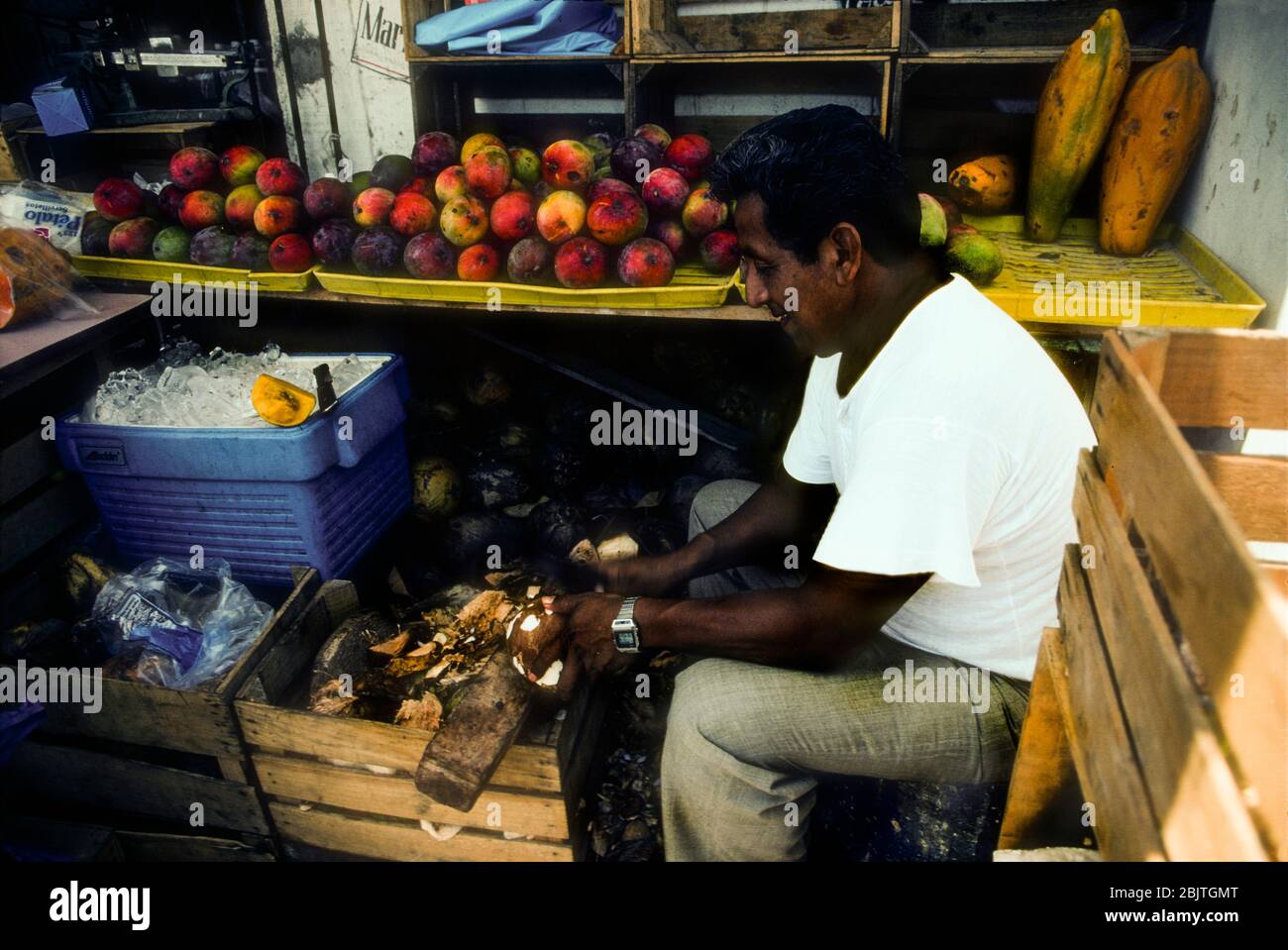 Man peeling vegetables outside a grocery store in Playa del Carmen ...