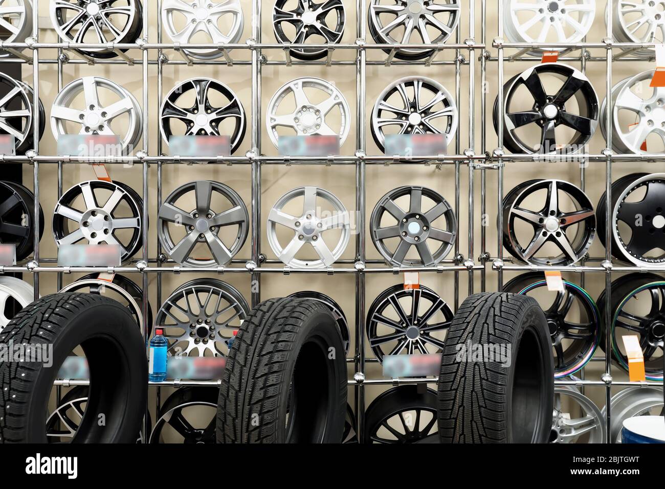 Rack with car wheels in automobile store Stock Photo - Alamy