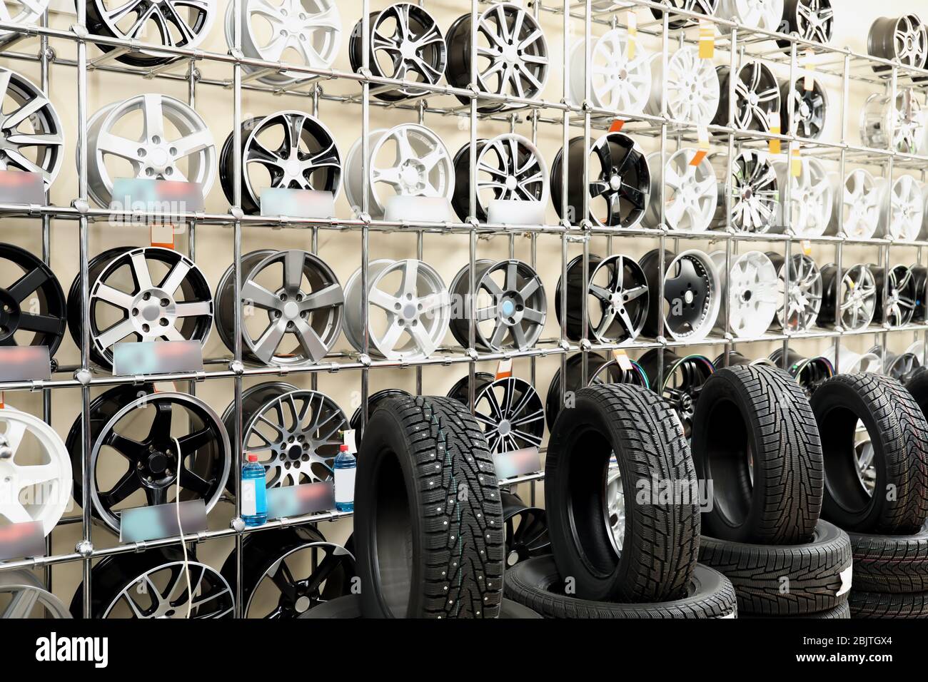 Rack with car wheels in automobile store Stock Photo - Alamy