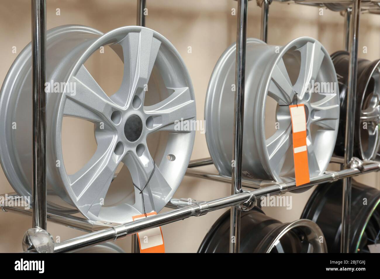 Rack with car wheels in automobile store Stock Photo - Alamy