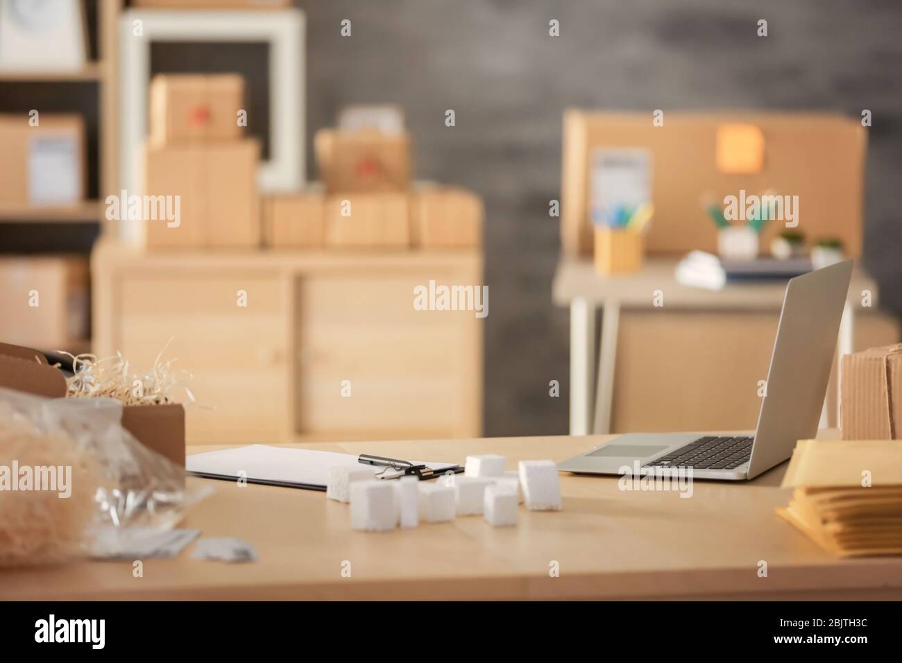 Laptop with parcels on workplace in home office Stock Photo - Alamy