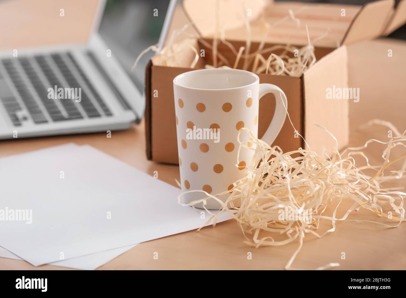 Open parcel box with cup on table in home office Stock Photo - Alamy
