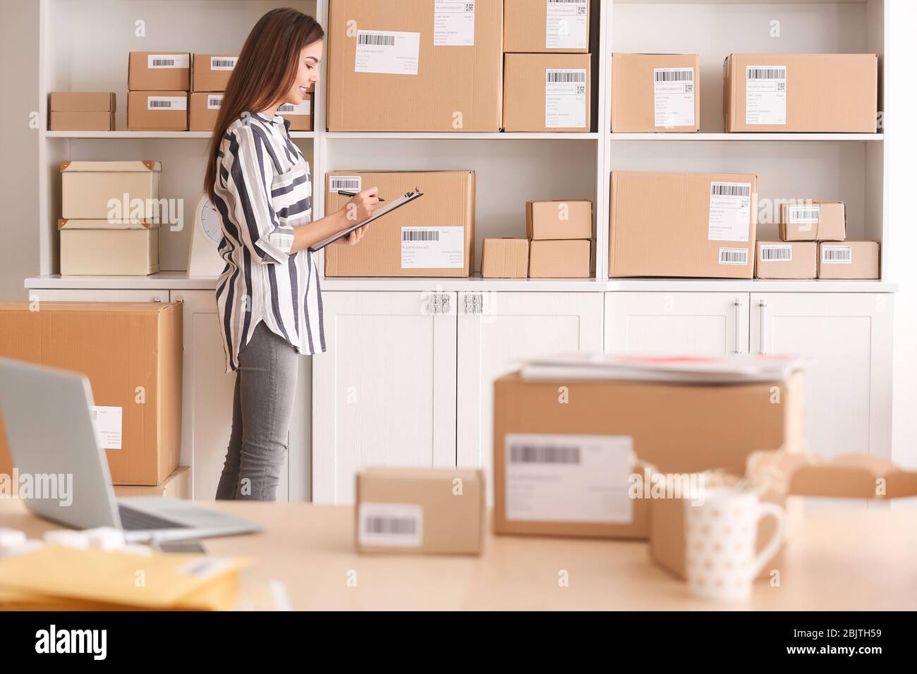 Young woman preparing parcels shipment hi-res stock photography and ...