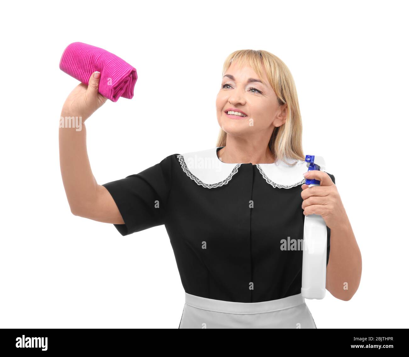 Portrait of mature woman in uniform with detergent and rag on white ...
