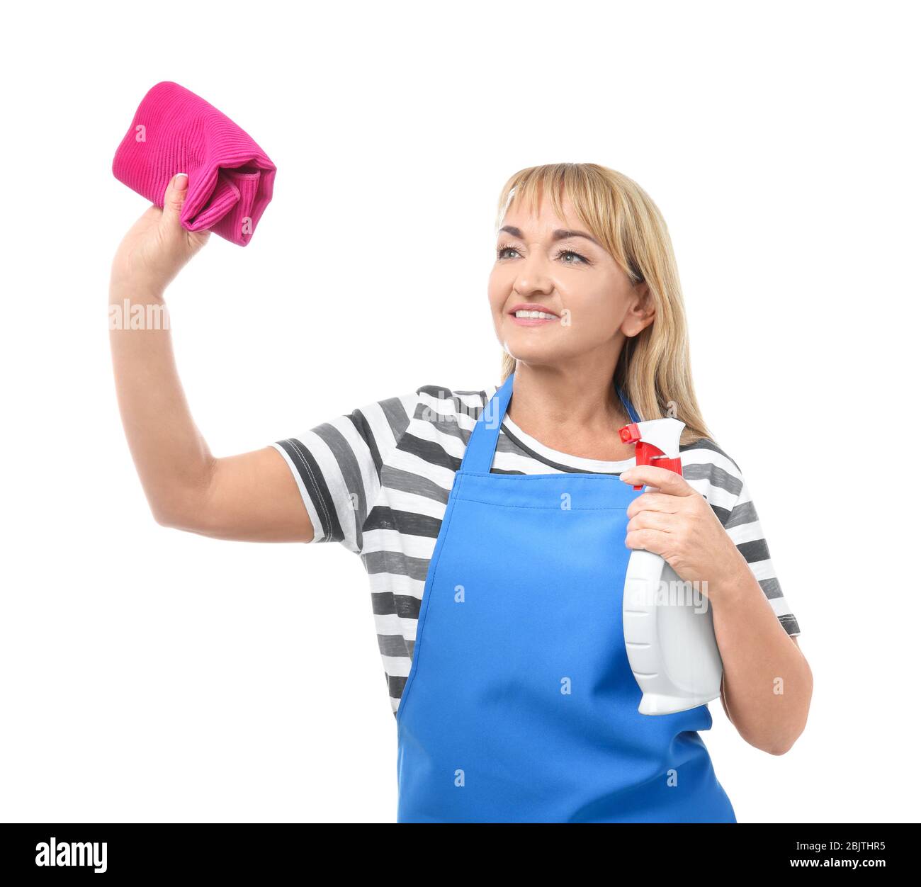 Portrait of mature woman in apron with detergent and rag on white ...