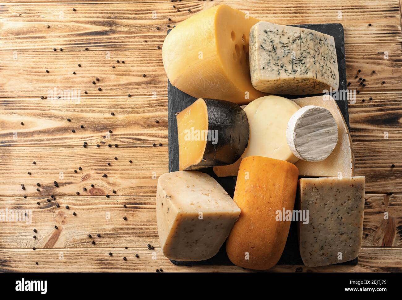 Different types of delicious cheese on wooden table Stock Photo - Alamy