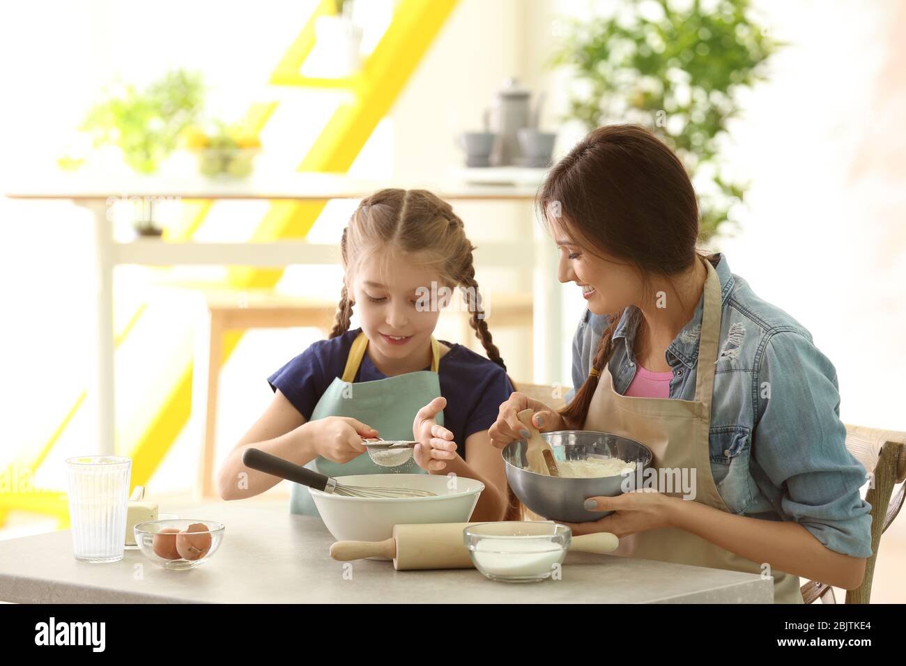 Mother and daughter preparing dough indoors Stock Photo - Alamy